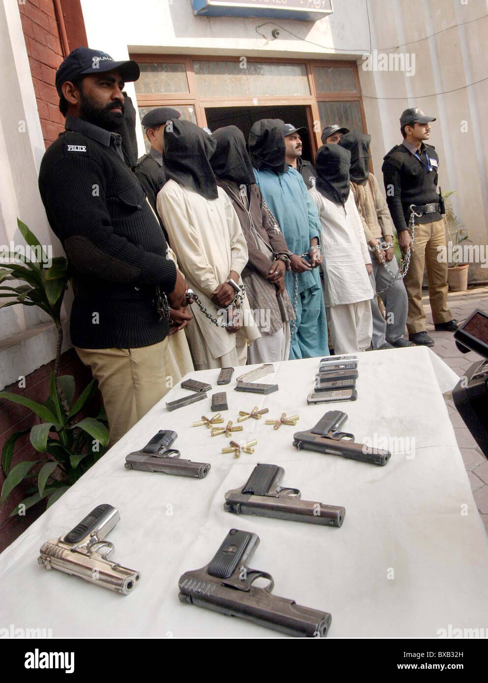 Police officials show handcuffed dacoits (face covered with cloths) who ...