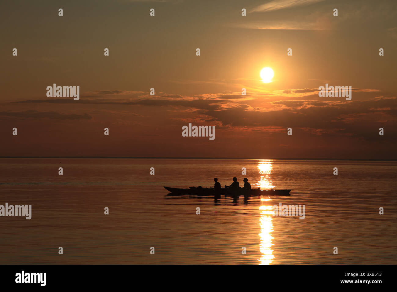 People in rowing boat during sunset Stock Photo - Alamy