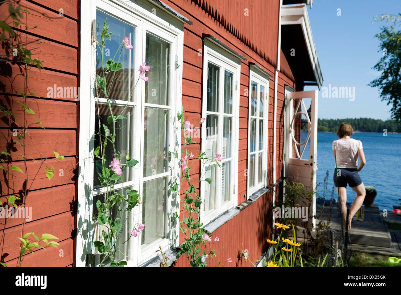 Woman standing outside house Stock Photo - Alamy