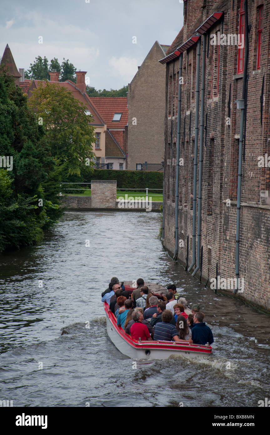 A canal cruise boat taking passengers on a tour of Bruges and its ...