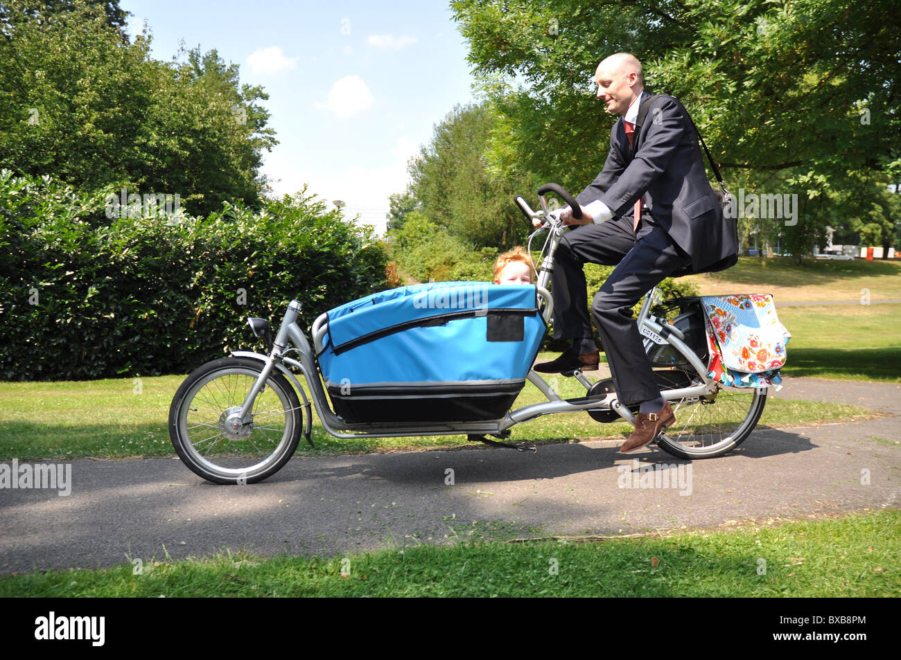 Business men enjoying riding his child to the creche Stock Photo - Alamy