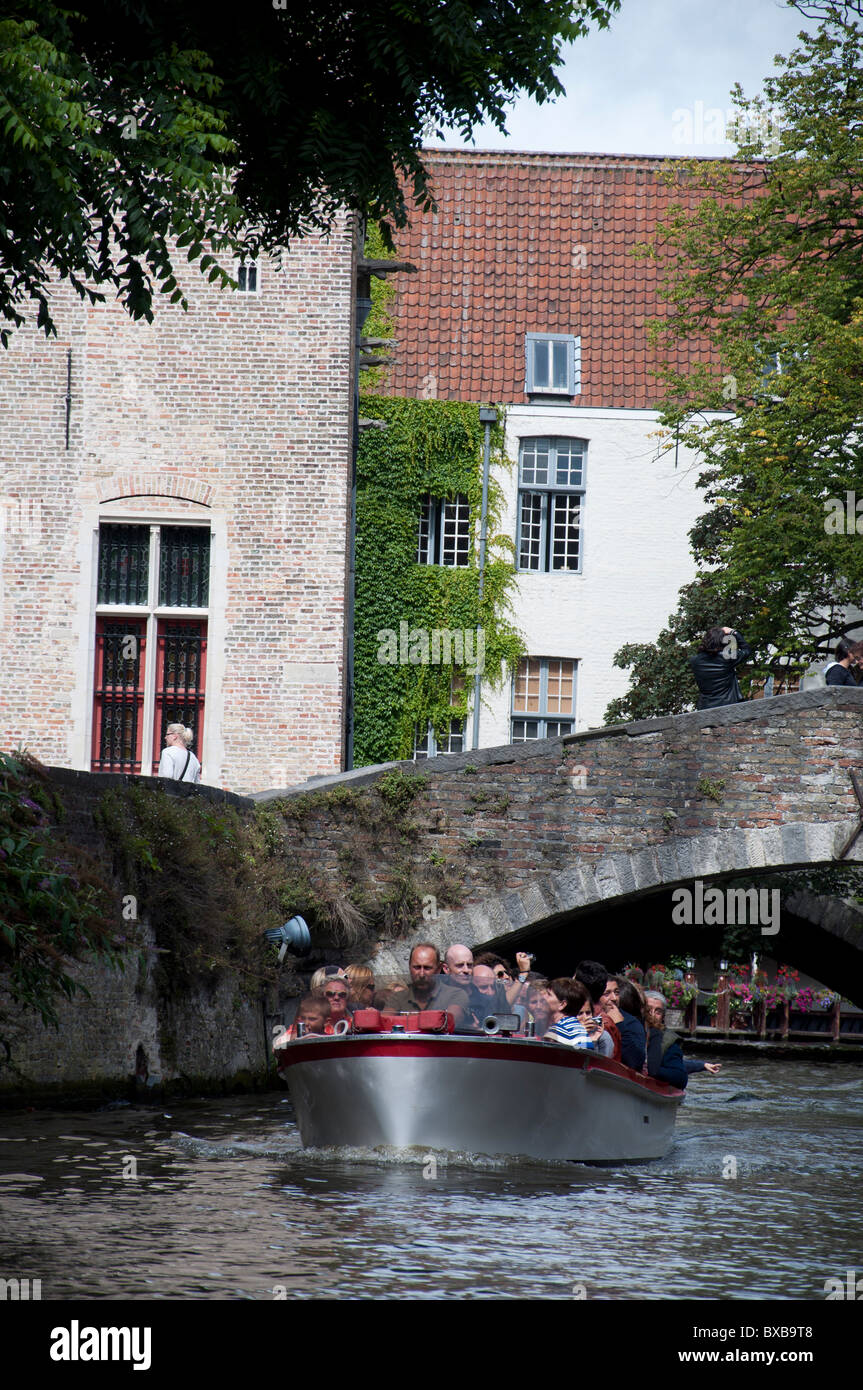 A canal cruise boat taking passengers on a tour of Bruges and its ...