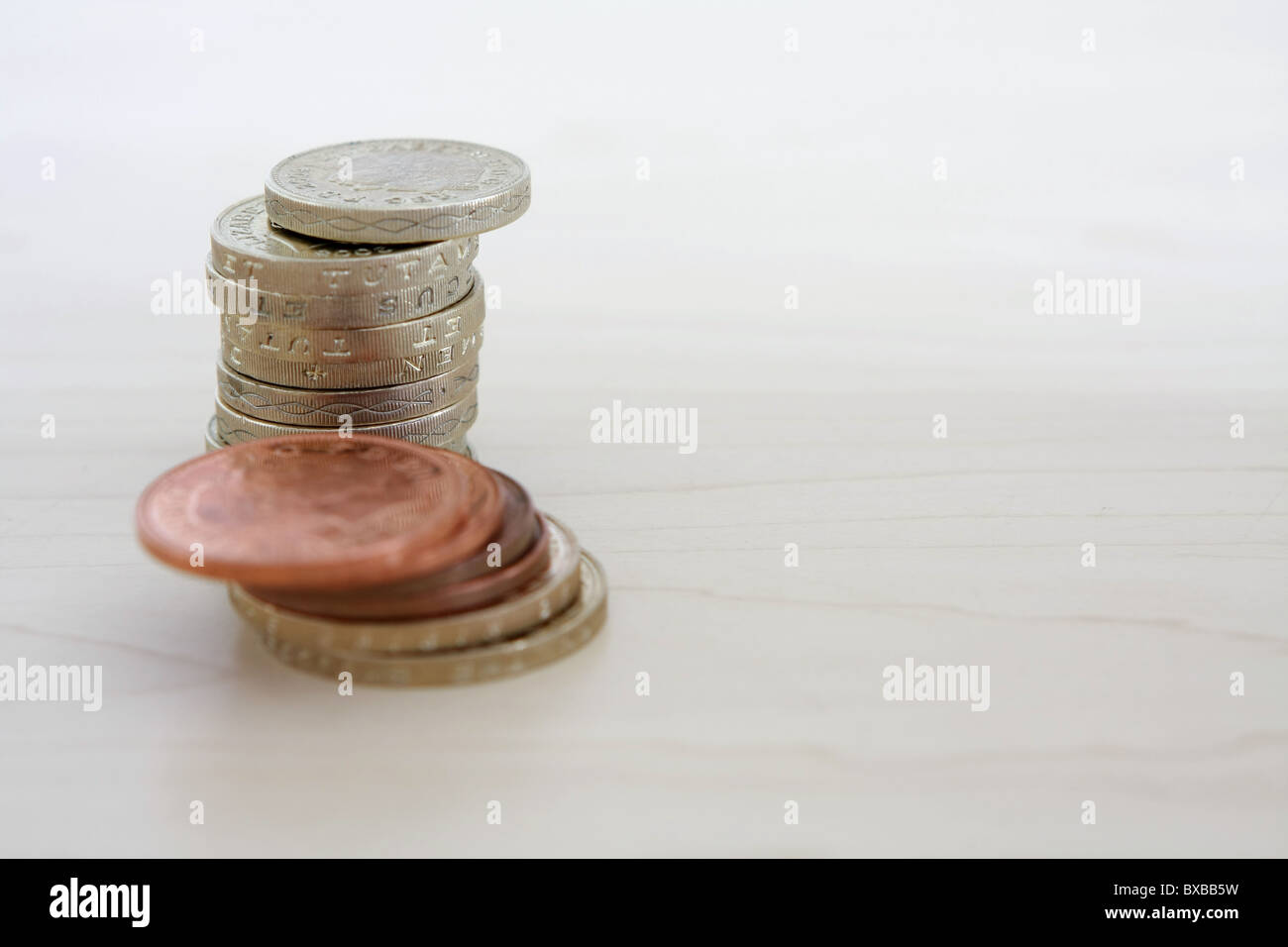 A stack of £1 sterling coins with some 2p coins on £2 coins in front ...