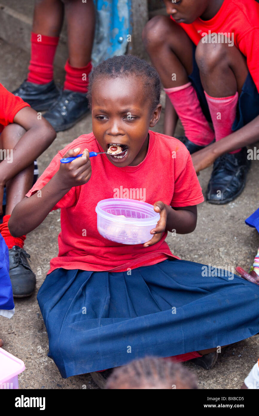 Girl eating food provided at Maji Mazuri School in the Mathare slums ...