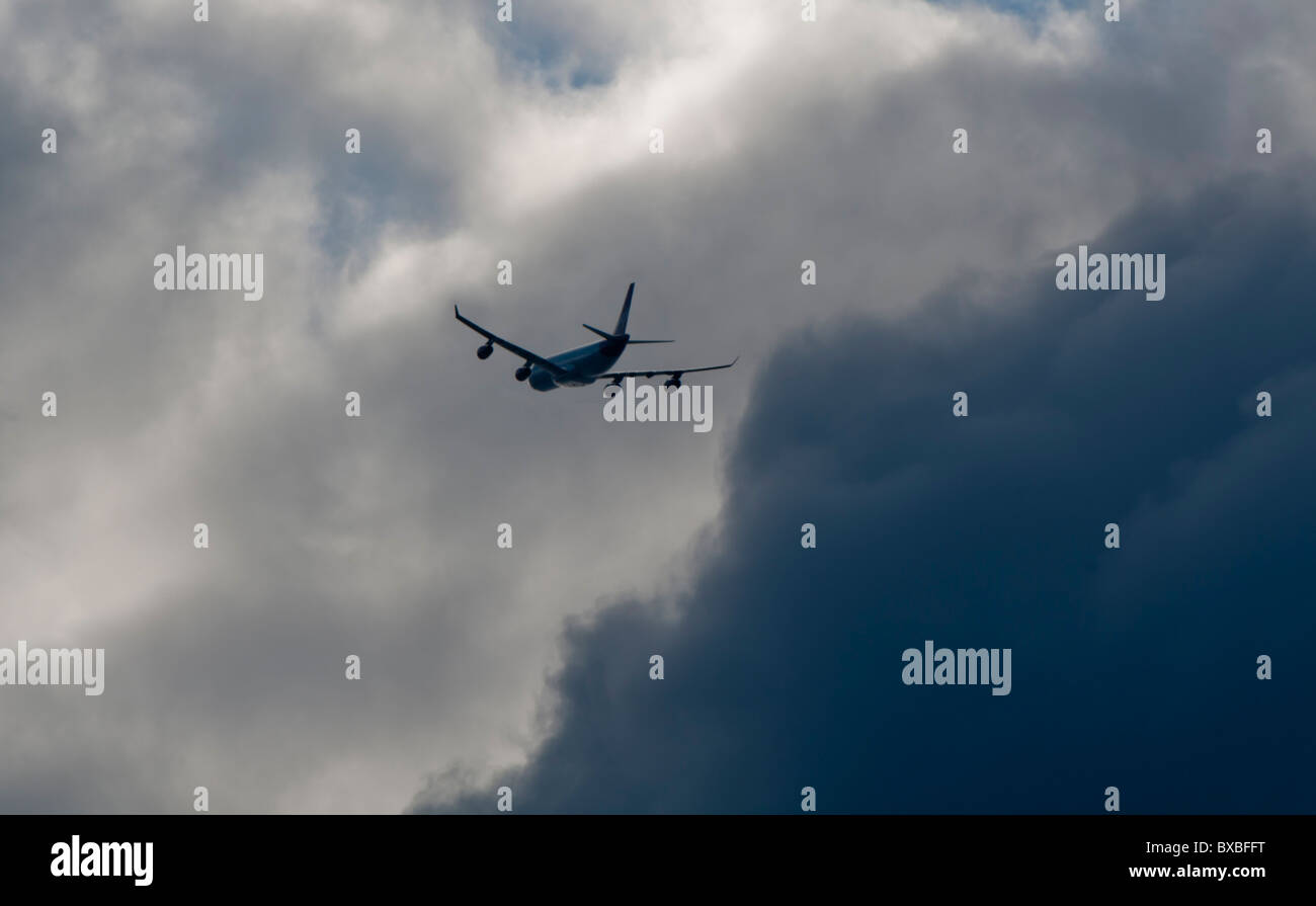 Airplane with storm clouds Stock Photo - Alamy