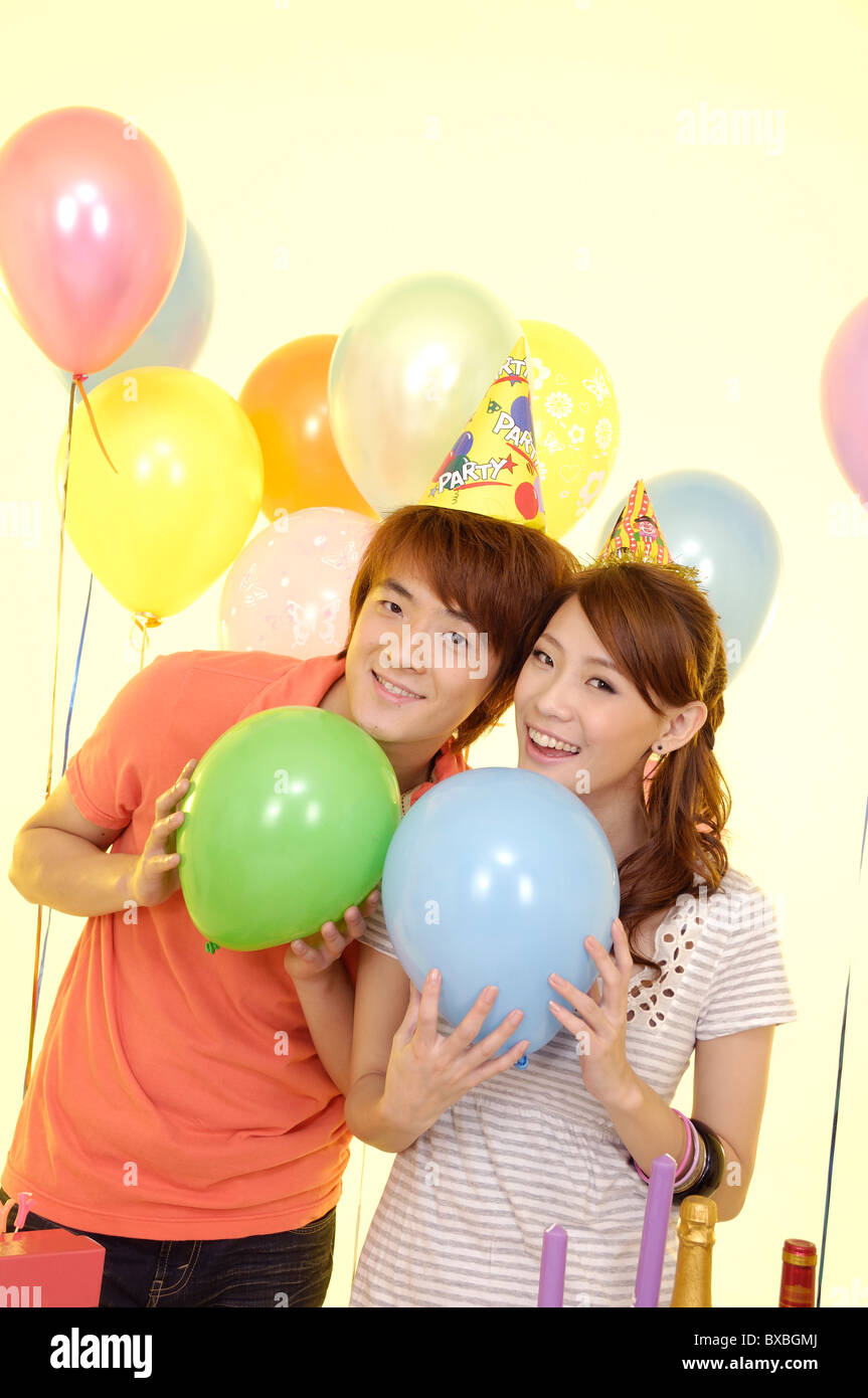 Friends holding balloons in a birthday party Stock Photo - Alamy