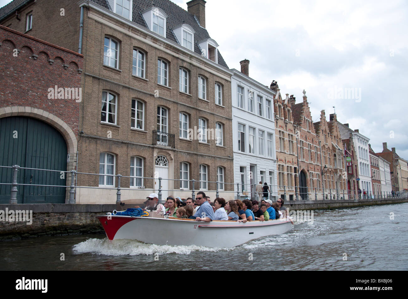 A canal cruise boat taking passengers on a tour of Bruges and its ...