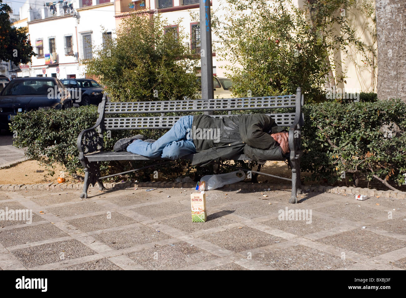 A homeless man sleeping on a bench in a street, Seville, Spain Stock ...