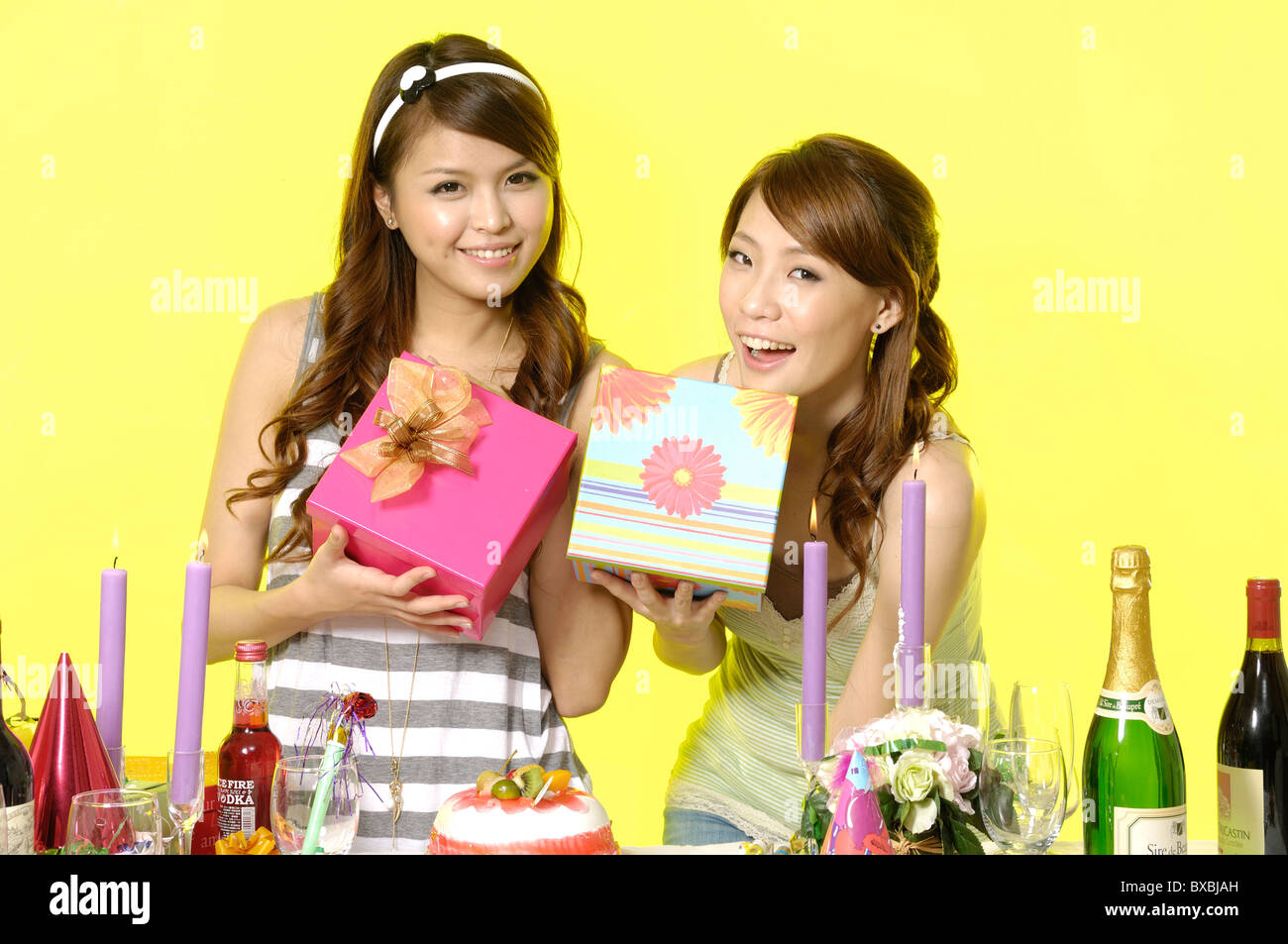 Female friends holding gifts in a birthday party Stock Photo - Alamy