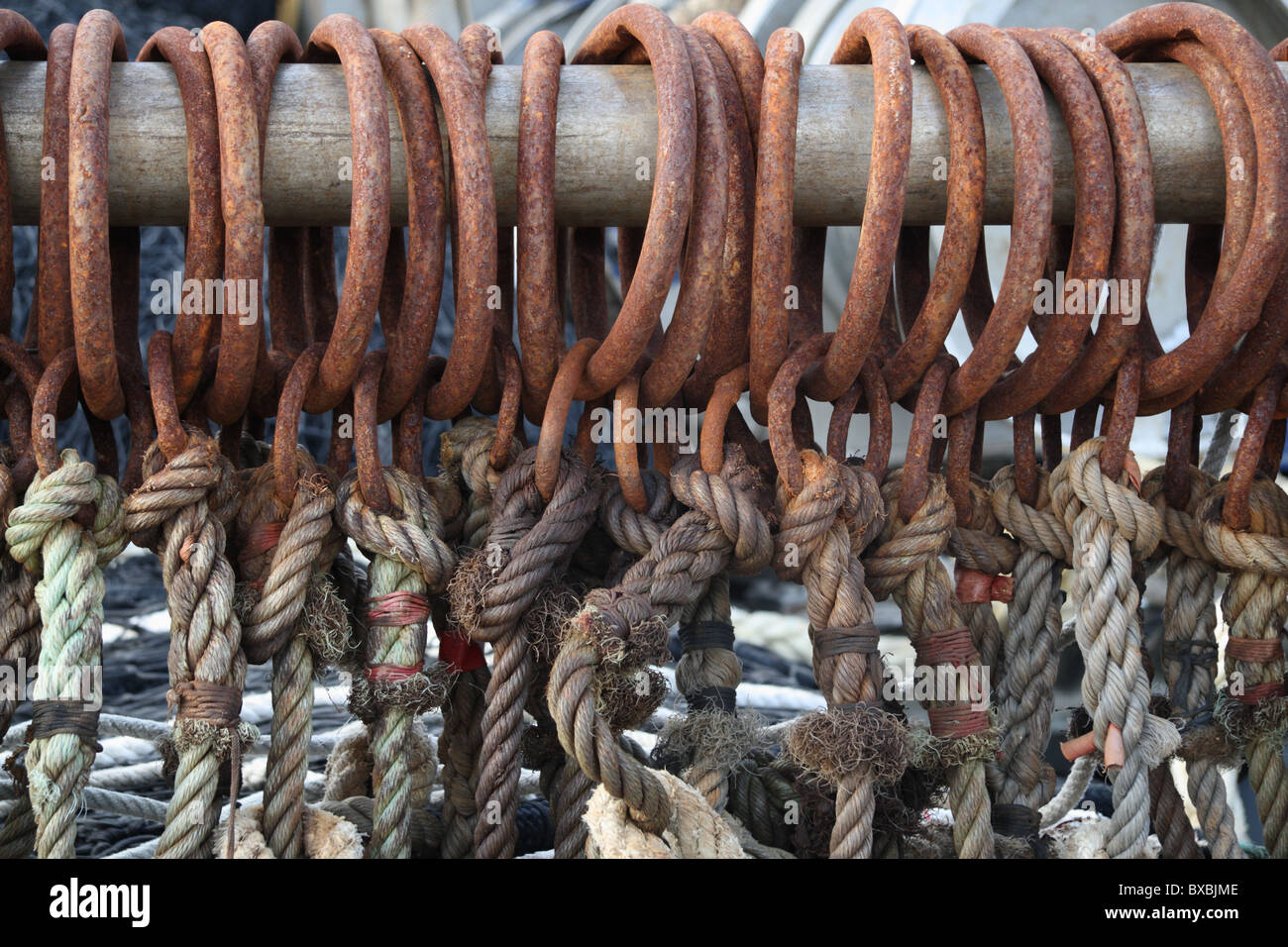 Fishing ropes suspended on rusty rings Stock Photo - Alamy