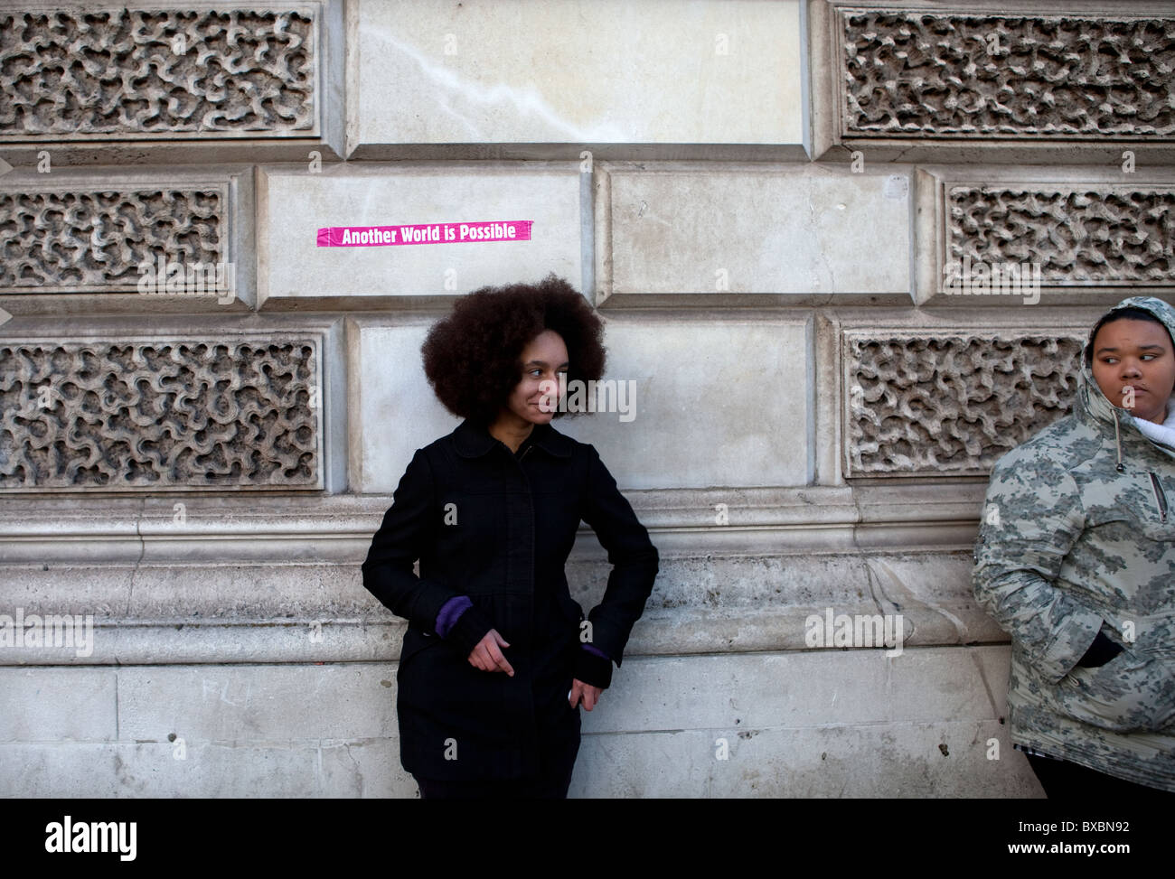 Youth standing under protest sign Stock Photo - Alamy
