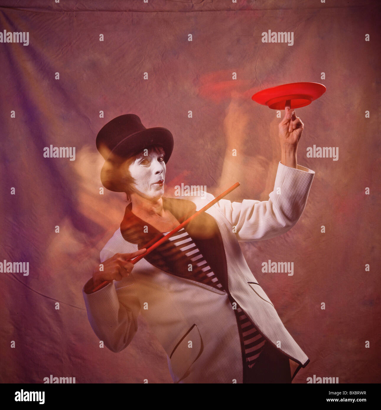 One female White face, faced, top hat mime performs plate twirl spin ...