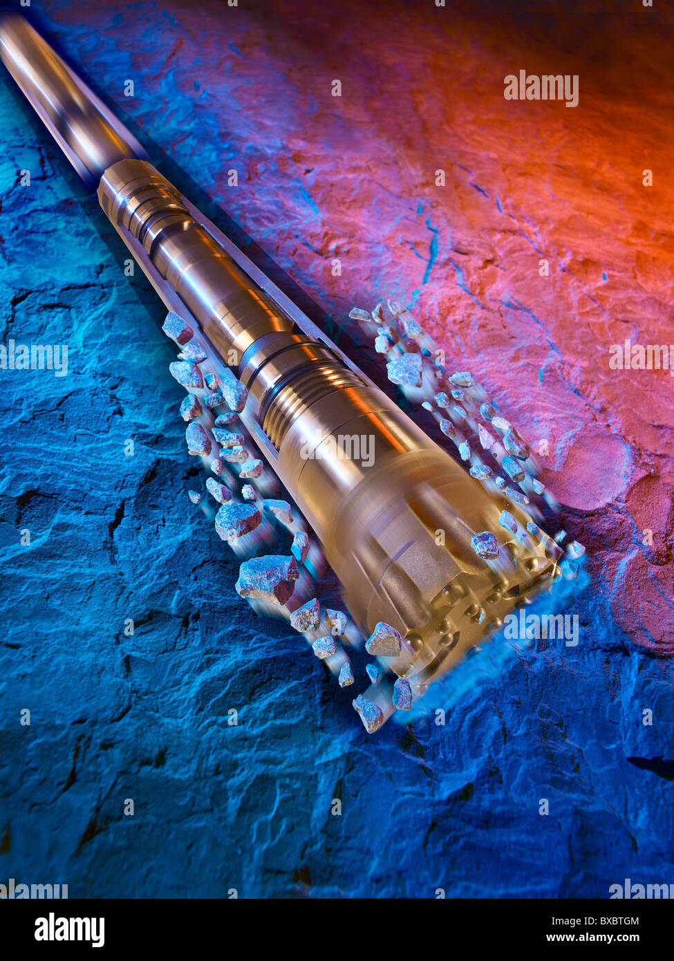 Cut away view of drill bit cutting through layers of stone, rock, mud ...