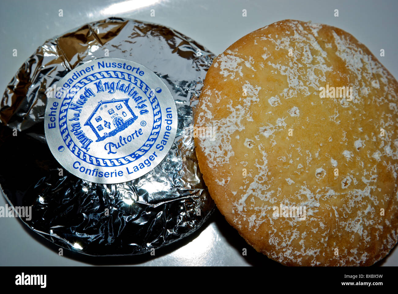 Foil wrapped and unwrapped St Moritz special nut torte pastry on plate ...