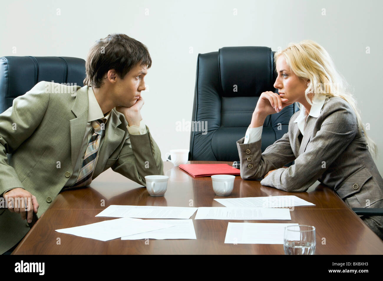 Two business people in front of each other staring hard at each other ...