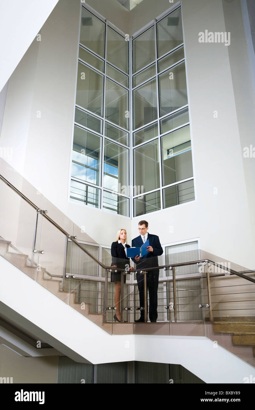 Businessman holding blue paper-case in his hands and showing documents ...
