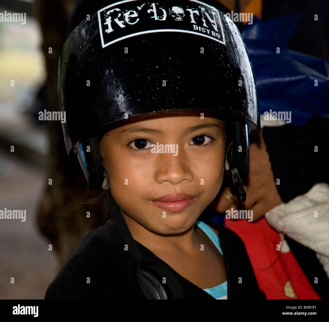 Young child wearing a helmet in Bali Stock Photo - Alamy