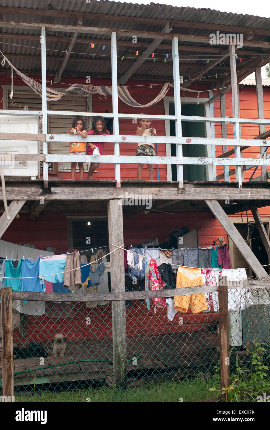 Three young children looking out over veranda in Belize, Central ...