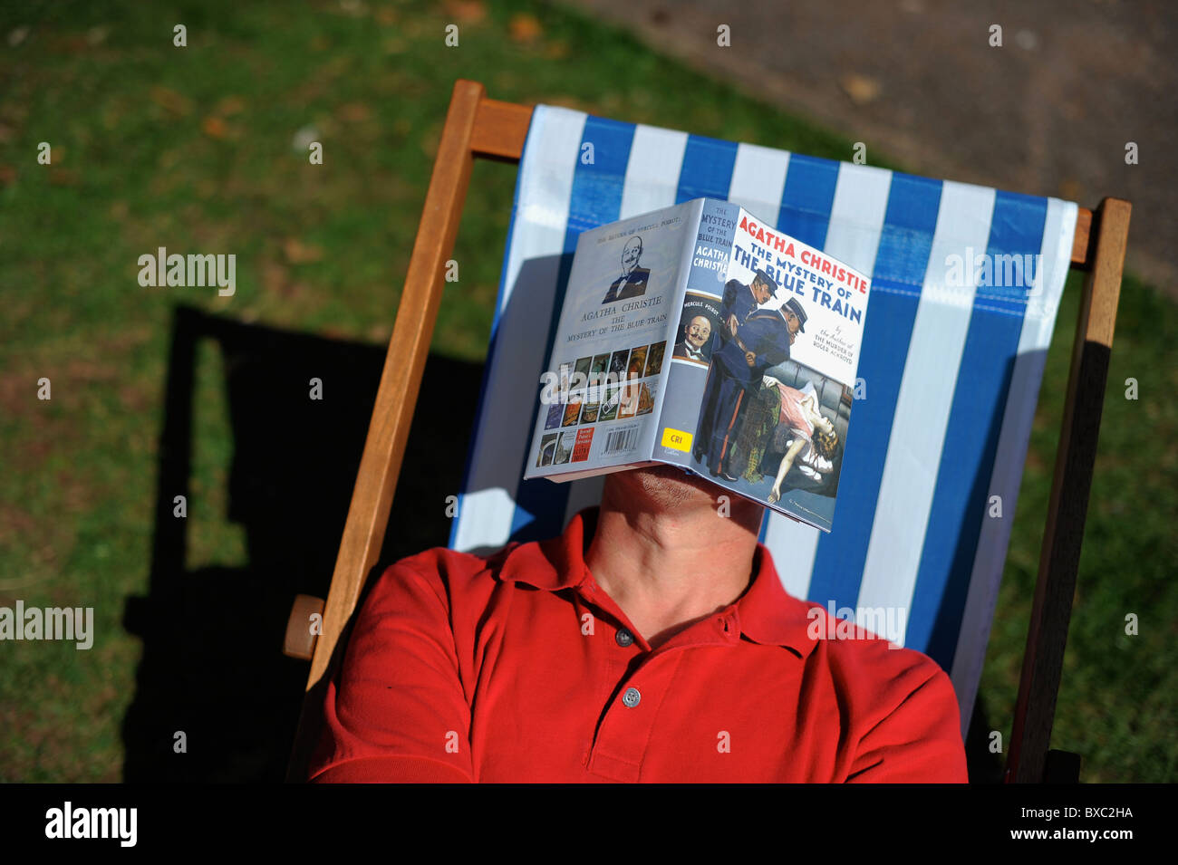 A Man Sleeping On A Deckchair With An Agatha Christie Book Over His