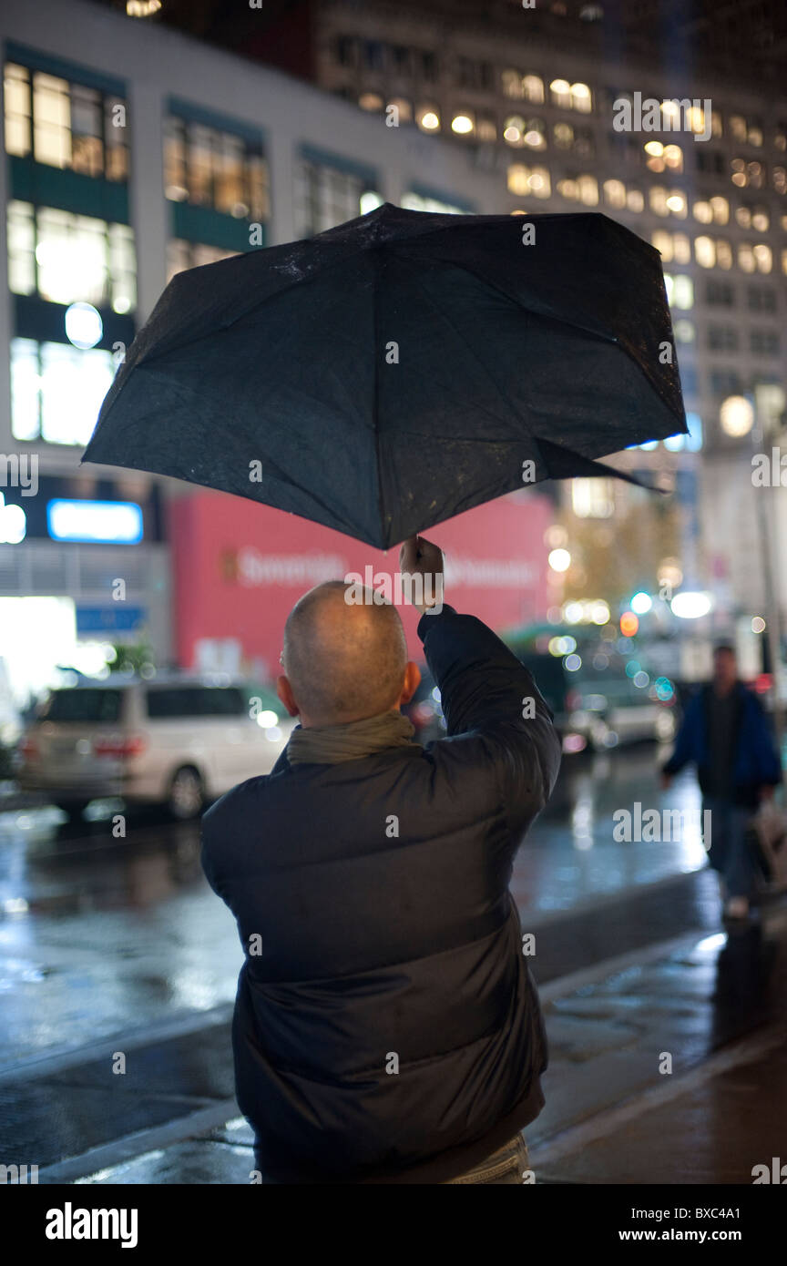 Man holding up an umbrella in Manhattan, New York City, U.S.A Stock ...