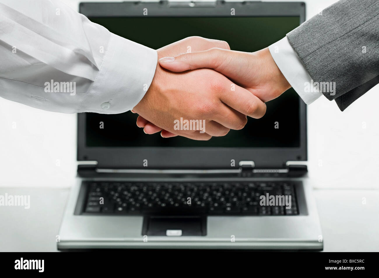 Woman and man shaking hands on the background of opened laptop Stock ...