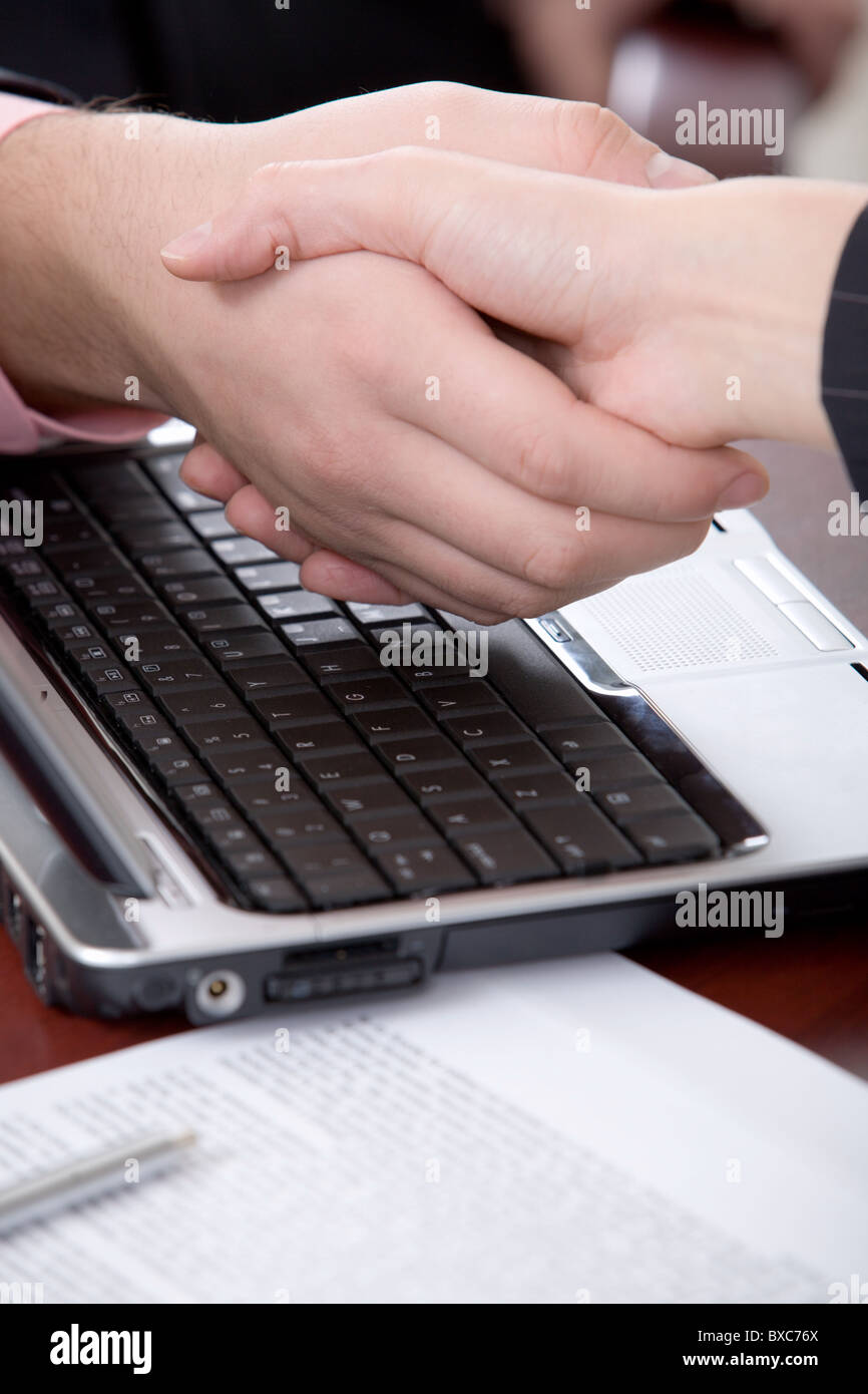 Business people shaking hands above the keyboard of laptop Stock Photo ...