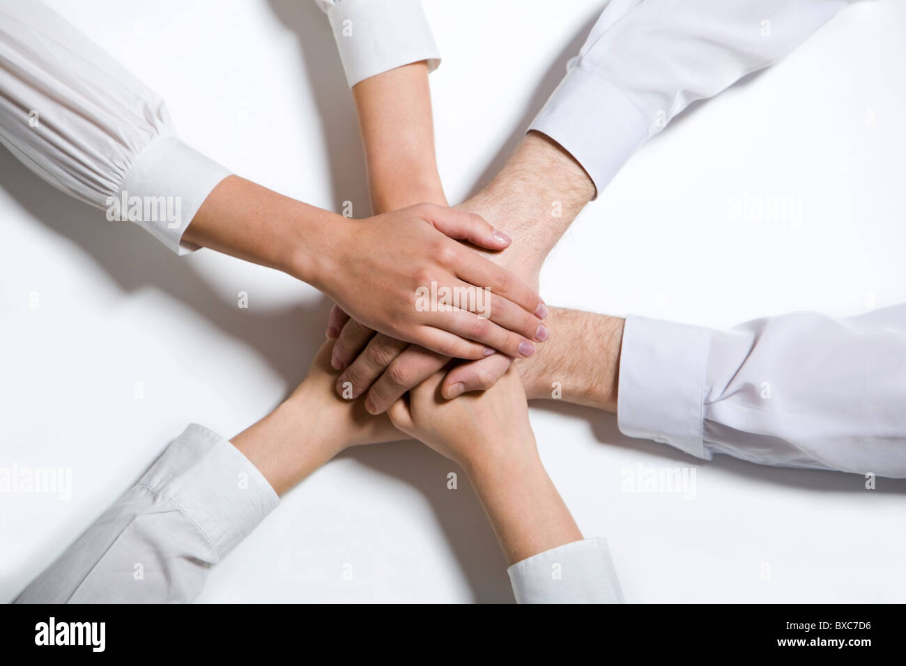 Isolated on white four joint human hands in white wear Stock Photo - Alamy