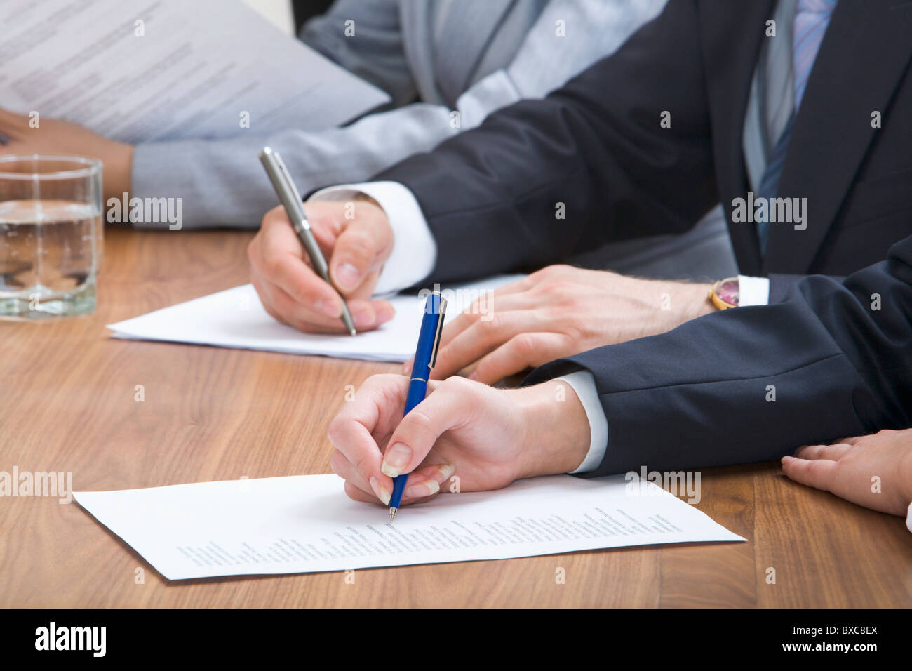 Human hands holding pens and papers, making notes in documents on the ...