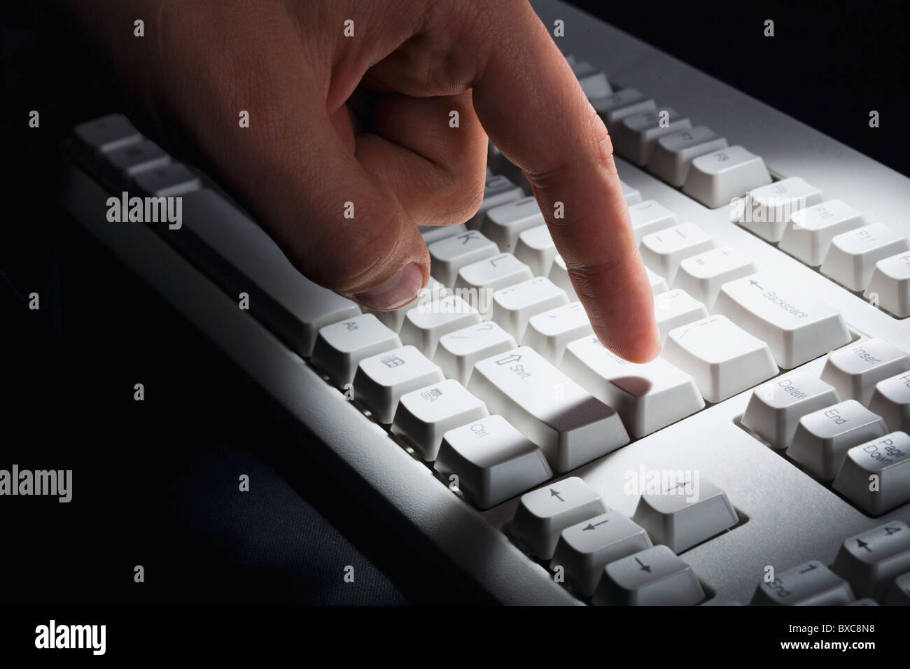 Image of human finger pointing at the enter key on white keyboard Stock ...