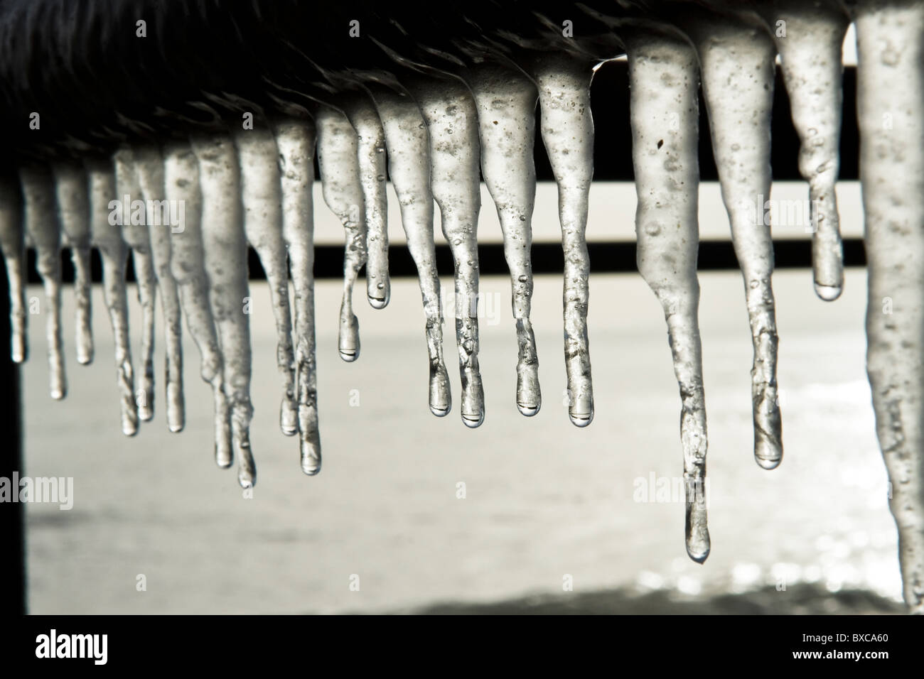 A row of icicles hanging from a metal pole Stock Photo - Alamy