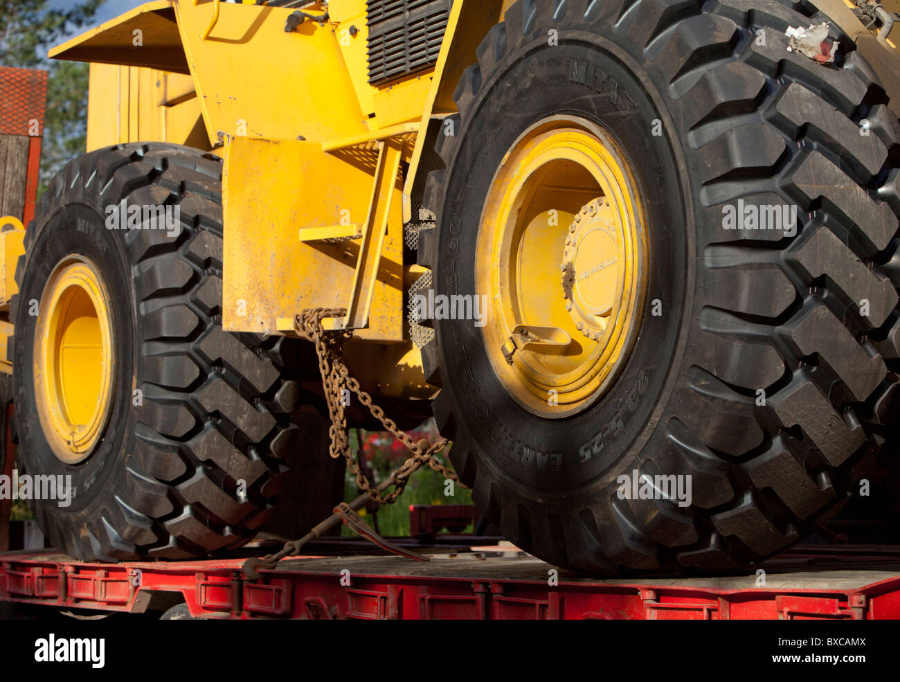 Front loader chained to truck trailer for transportation Stock Photo ...