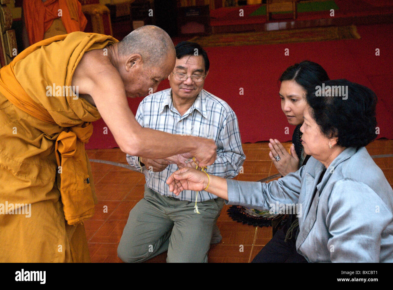 Monk blesses a family of traditional Stock Photo - Alamy