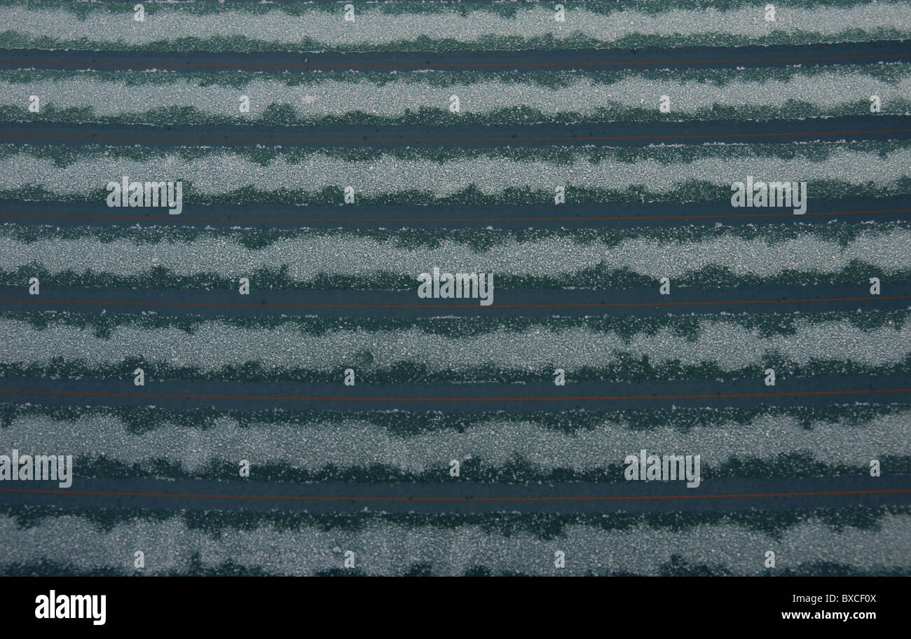 Early morning frost on car rear windscreen being melted by the screen ...