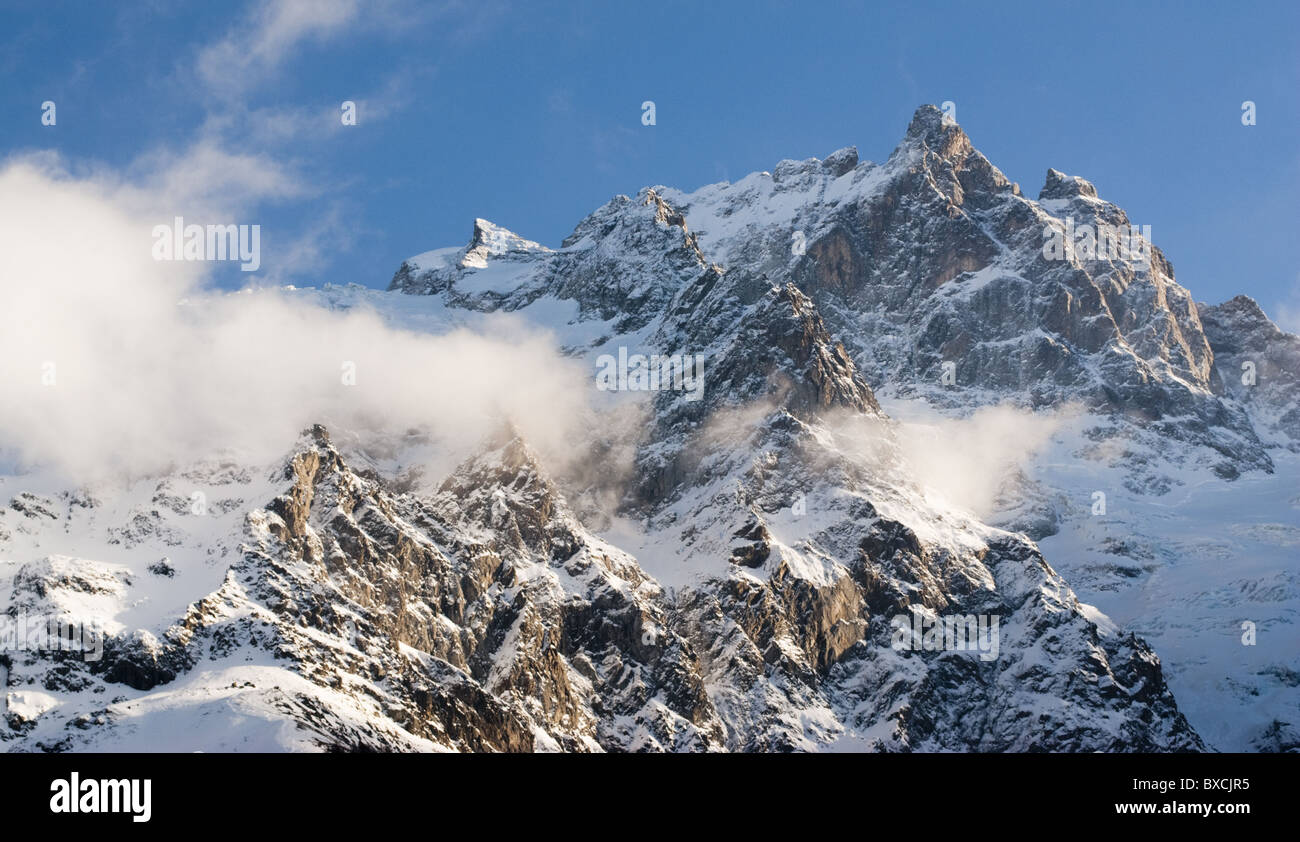 The steep, granite summit of La Meije, France, towering above clouds ...