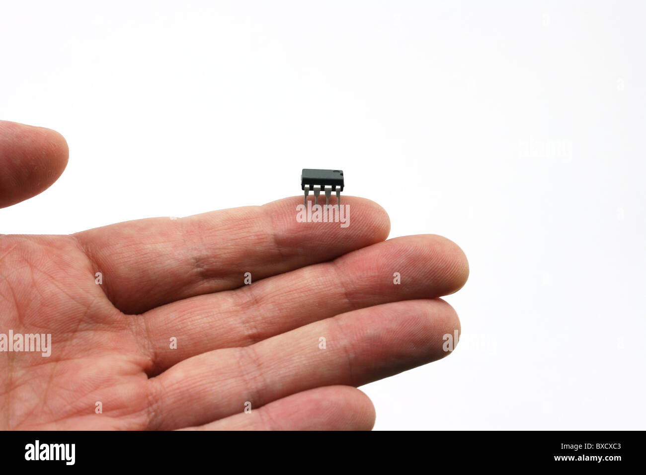 An isolated on hand on a white background holding a micro chip on the ...