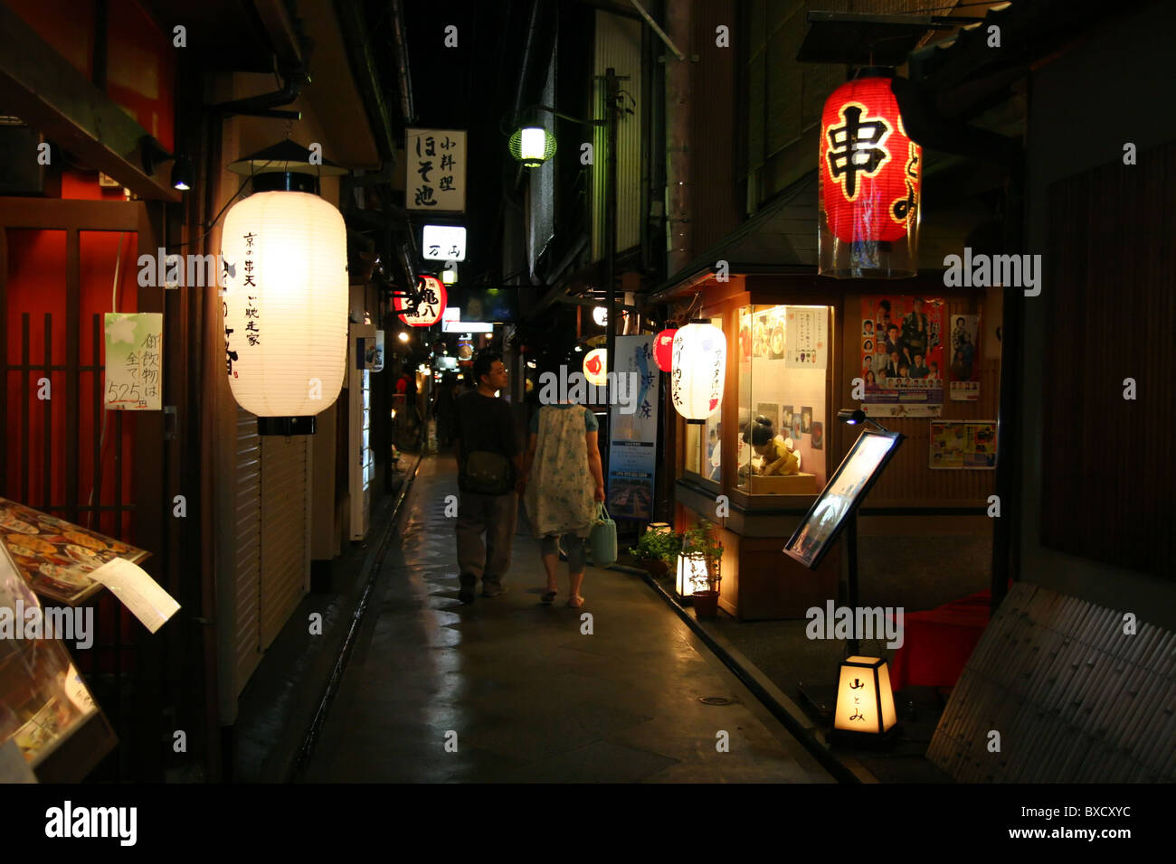 Glowing paper lanterns hung outside restaurants in a narrow alley in ...