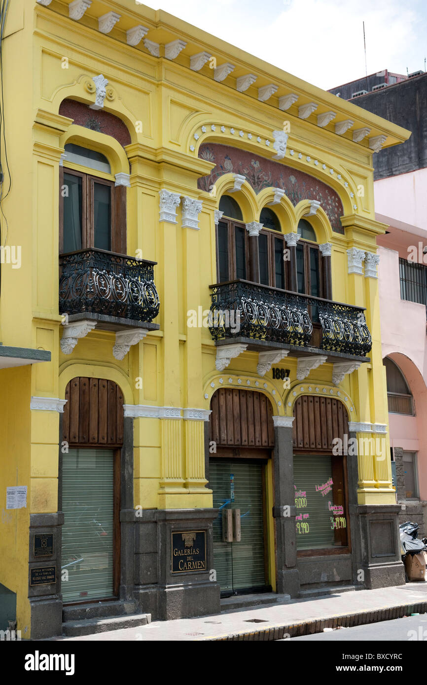 Yellow two storey building with wrought iron balcony and arched windows ...