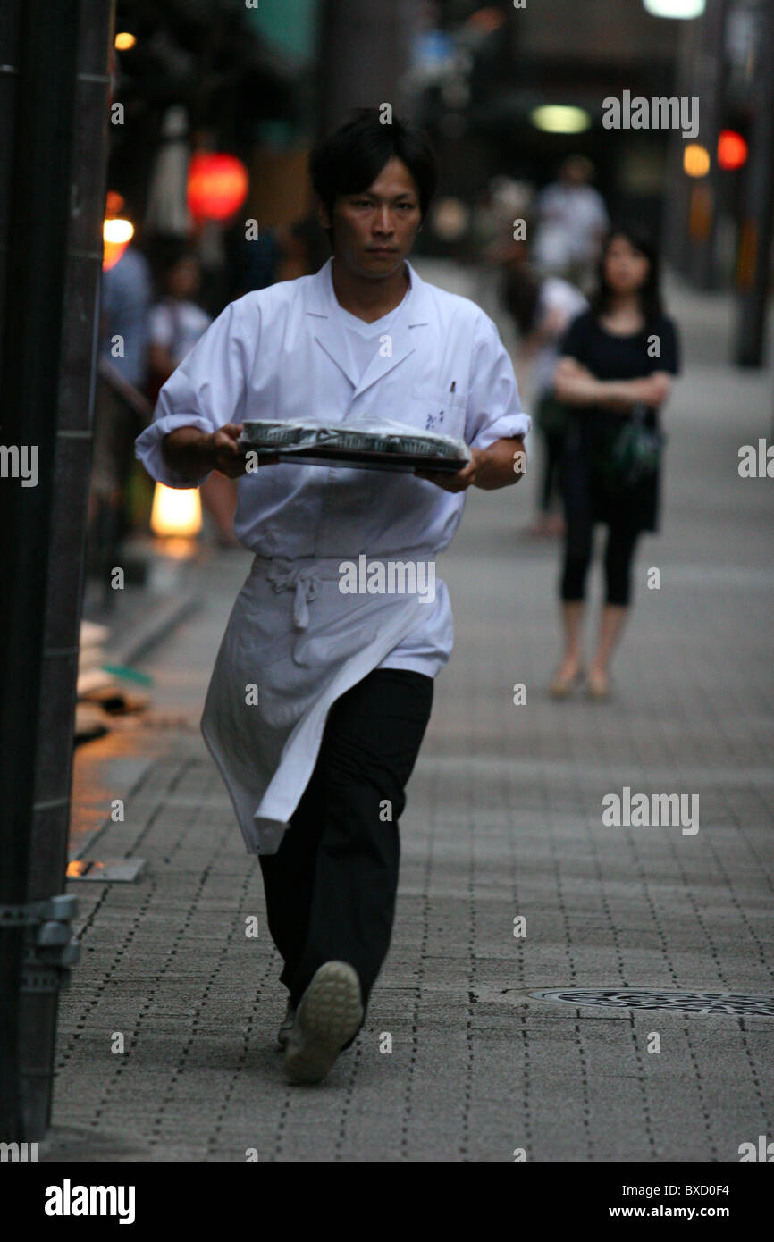 Cook delivering foods from a restaurant in Gion district, Kyoto Japan ...