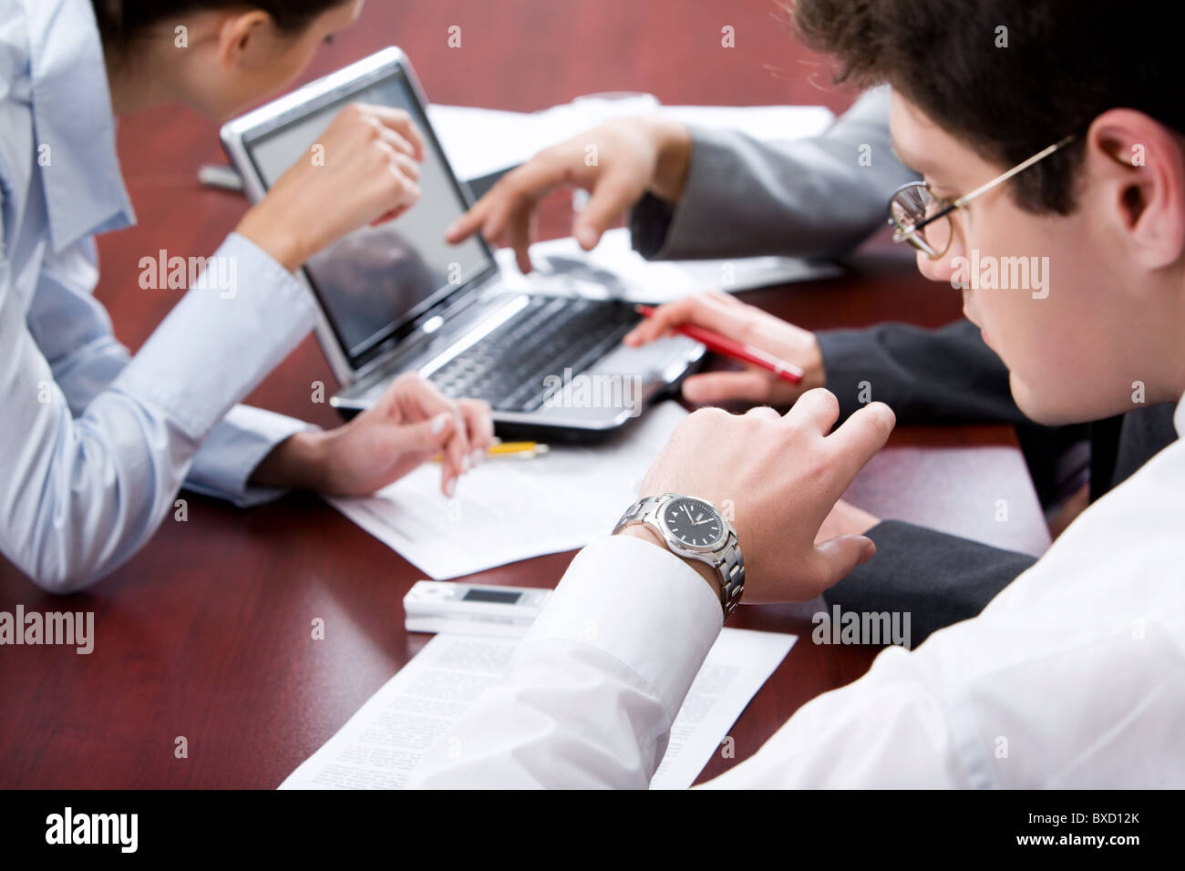 Business man looking at his wrist-watch in a working environment Stock ...