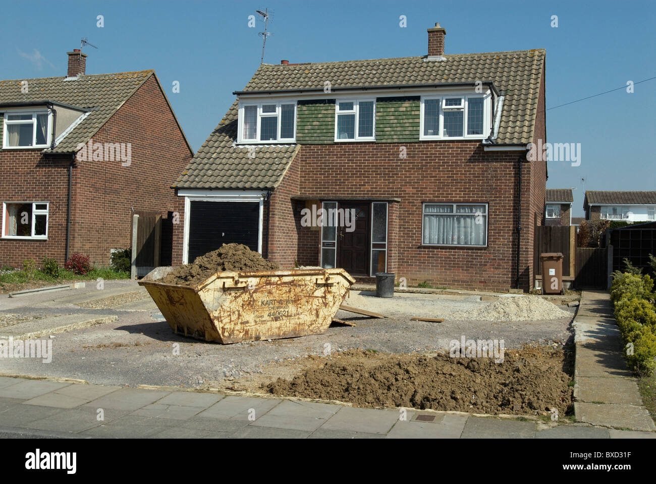 Skip outside new housing UK Stock Photo - Alamy