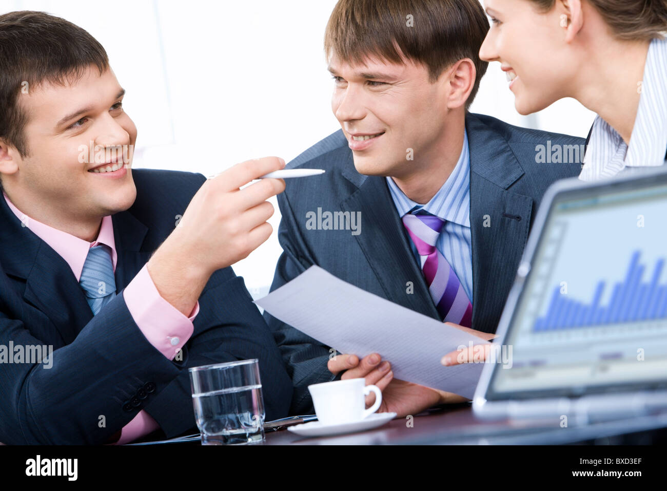 Portrait of three people discussing a working plan at a table Stock ...