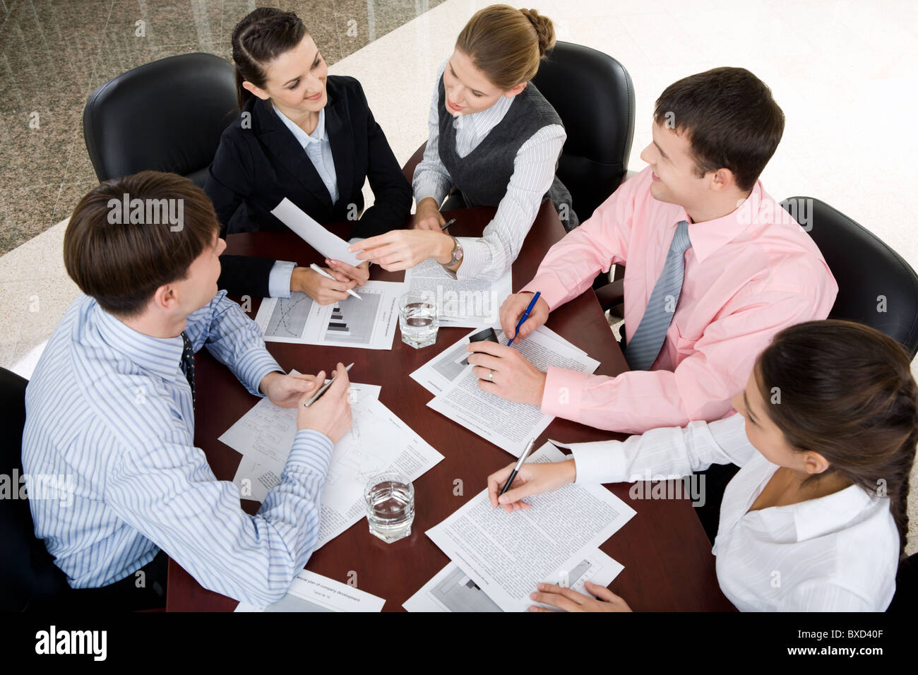 Businesspeople gathered around the table for a meeting, brainstorming ...