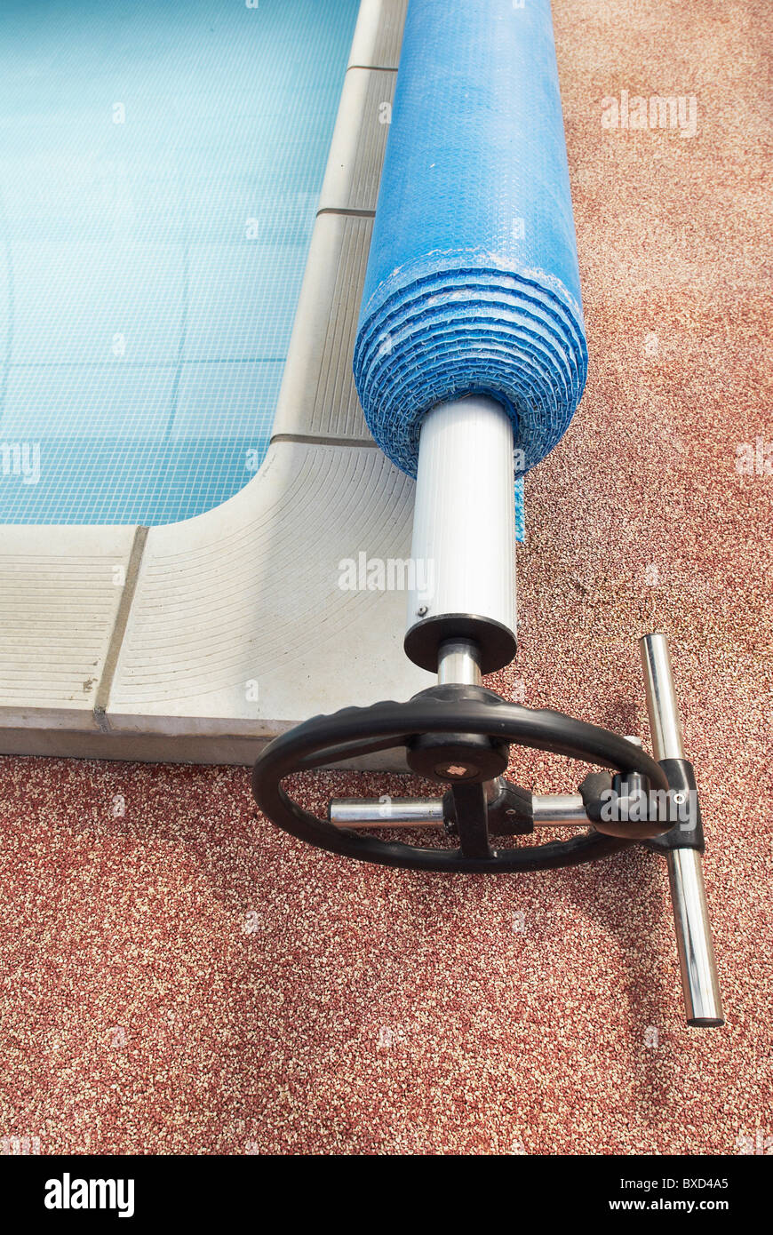 Hand wheel operated swimming pool cover rolled up Stock Photo - Alamy