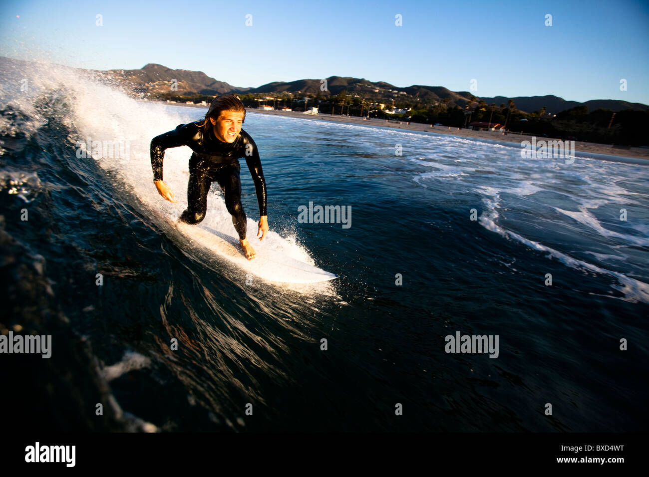 A male surfer smiles while riding a wave Stock Photo - Alamy