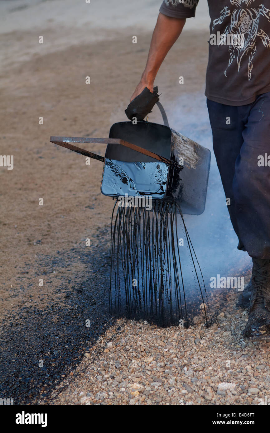 pouring tar on the road Stock Photo - Alamy