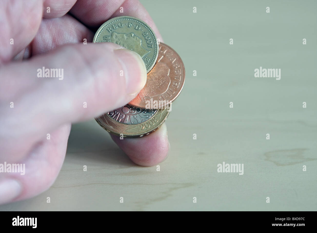 Some sterling coins held between and index finger and thumb Stock Photo ...