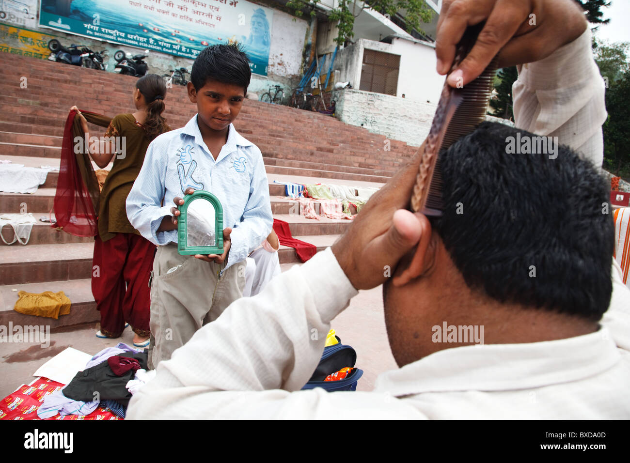 A man combs his hair after bathing in the holy Ganges river in ...
