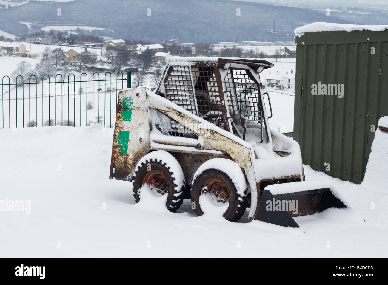 Digger standing in the snow ready for work Stock Photo - Alamy