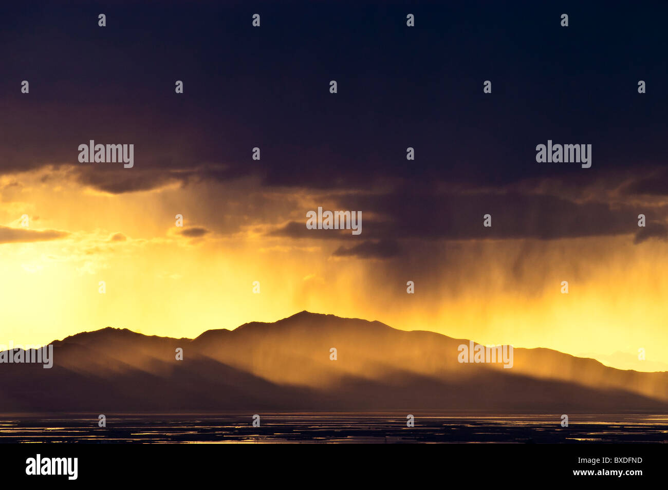 The Oquirrh Mountains cast shadows on rain falling from storm clouds ...