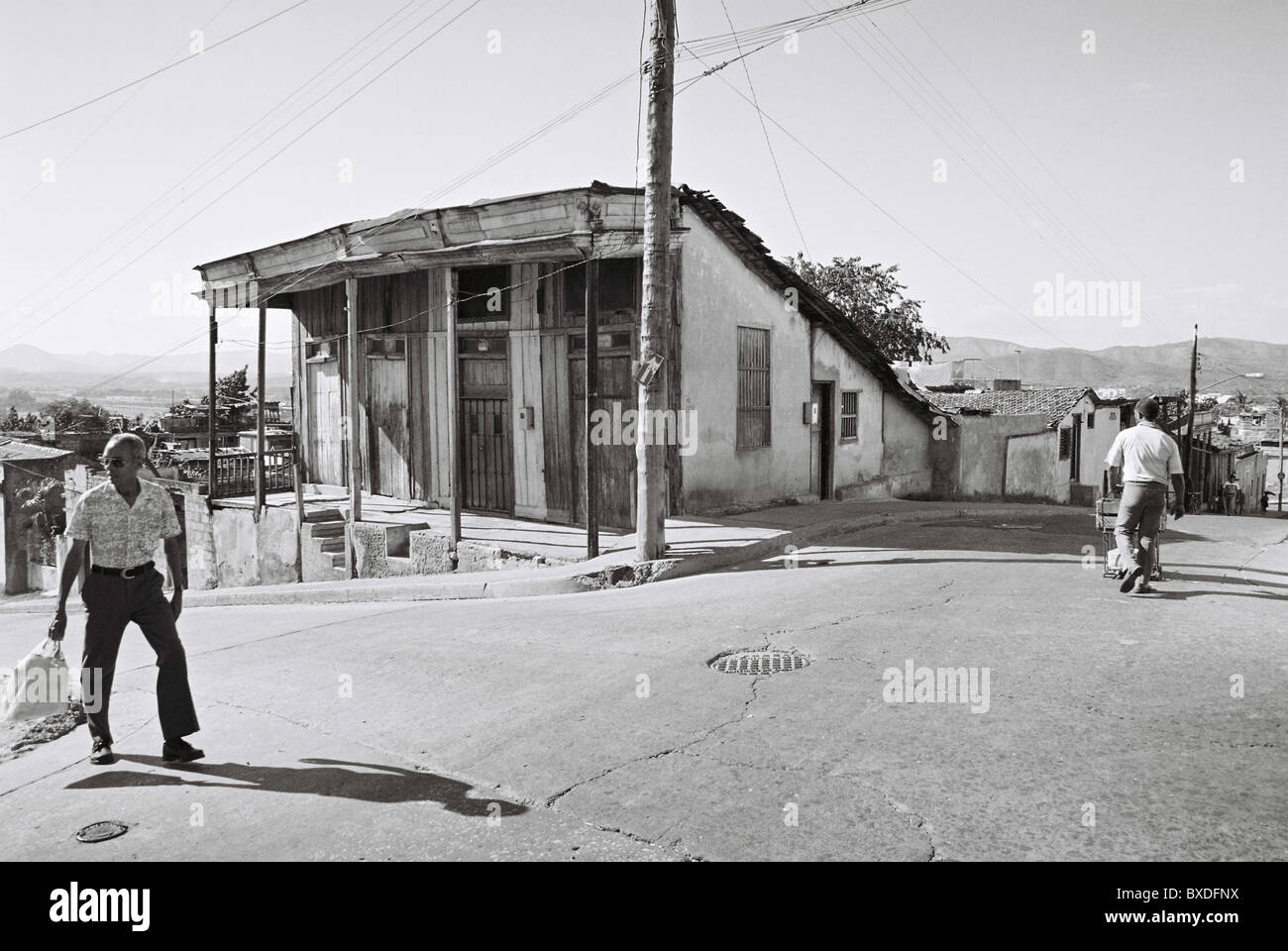 Two men walking in different directions on a street intersection in ...